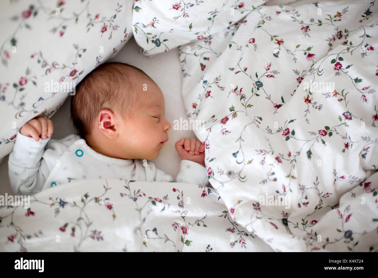 Beautiful newborn baby boy in bed. Infant lying down in bed. Healthy ...