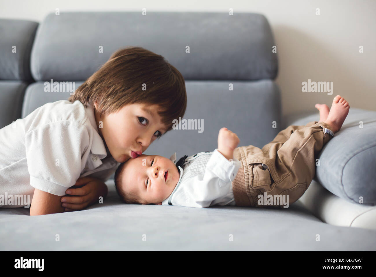 Sweet preschool boy, hugging with tenderness and care his little ...