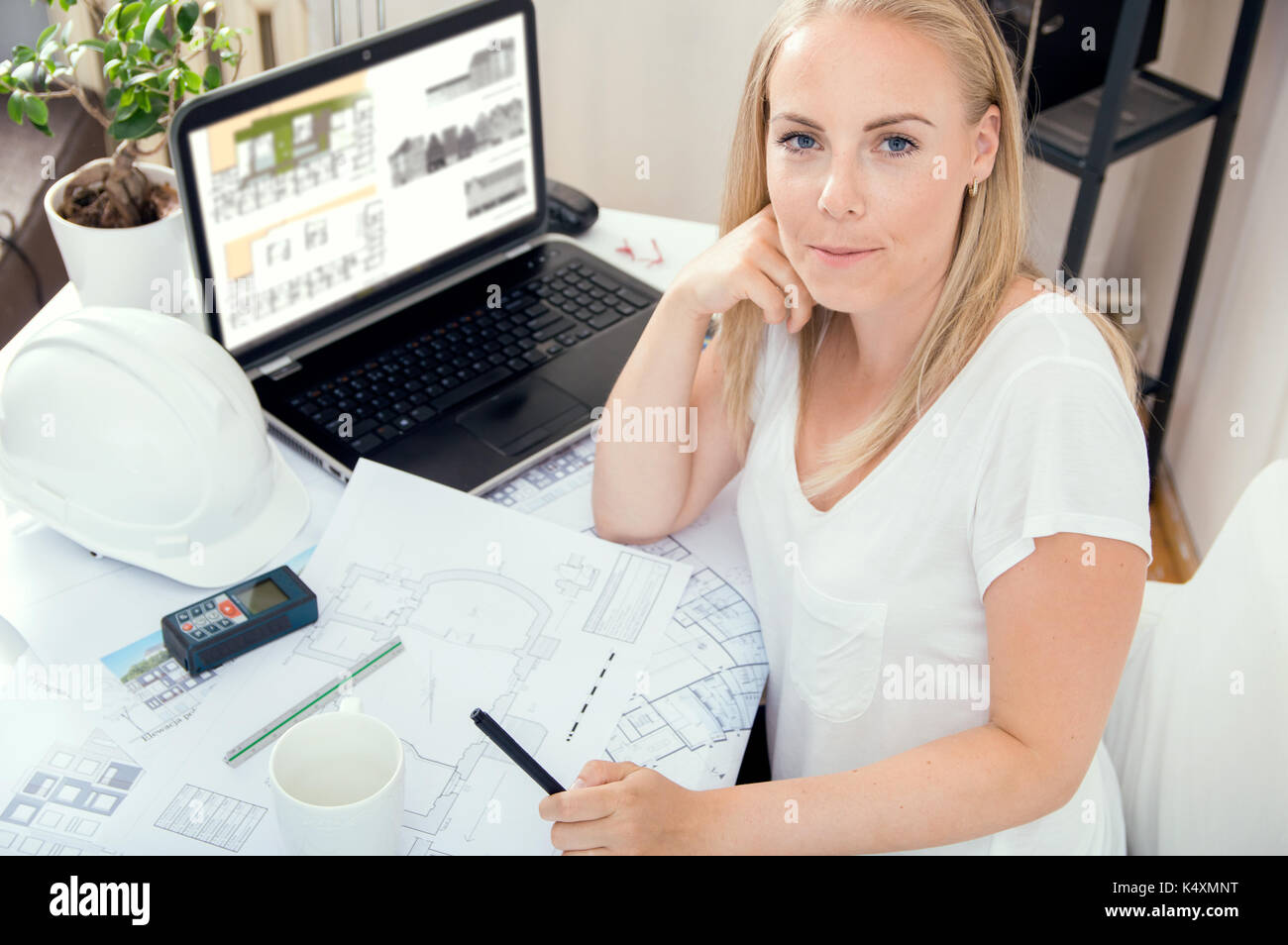 Young female architect is working at her new project at office Stock ...