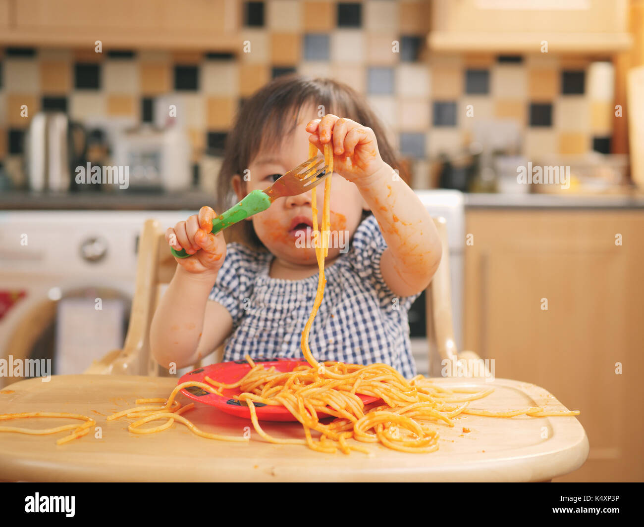 baby girl eating messy spaghetti at home Stock Photo - Alamy