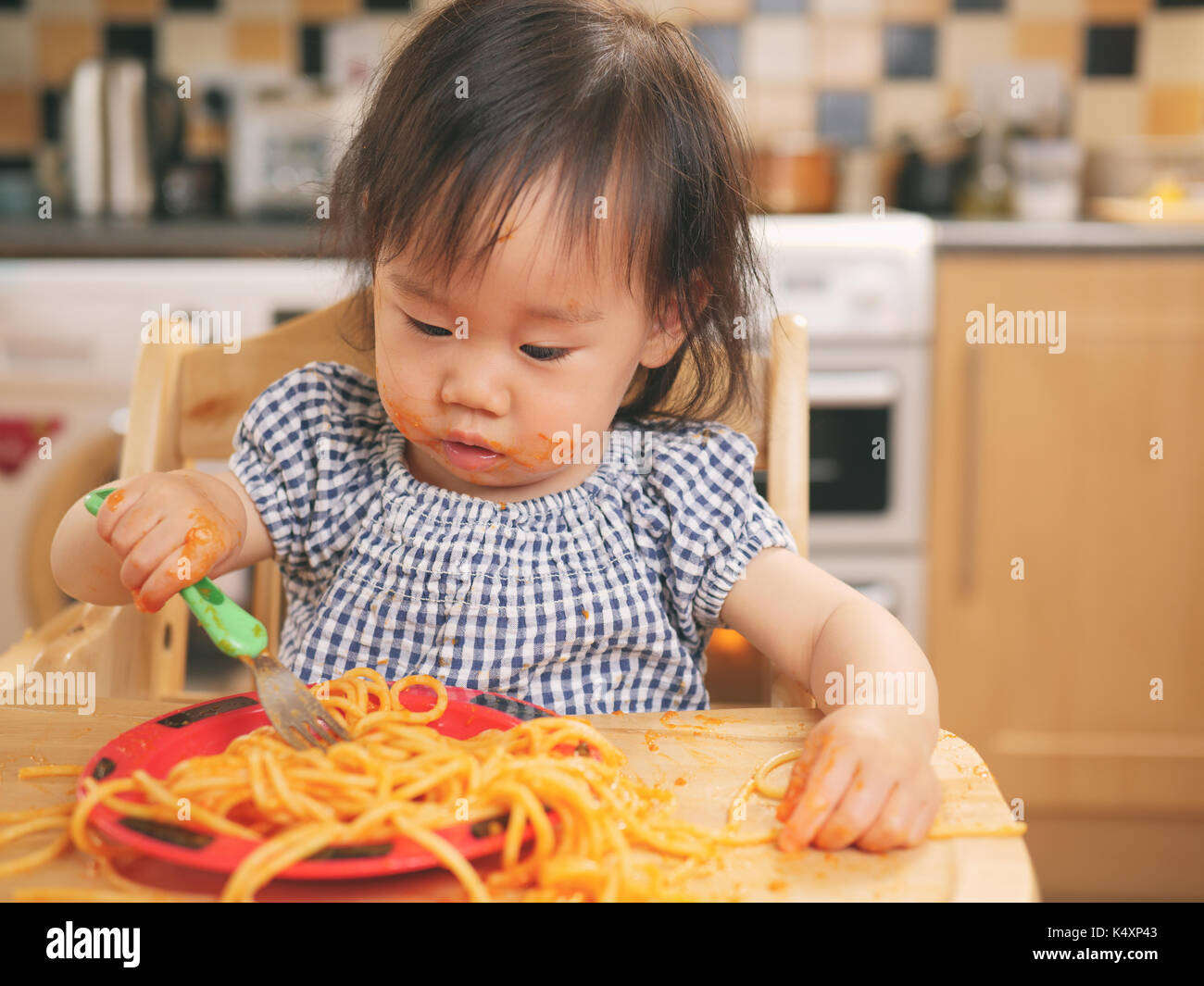 baby girl eating messy spaghetti at home Stock Photo - Alamy