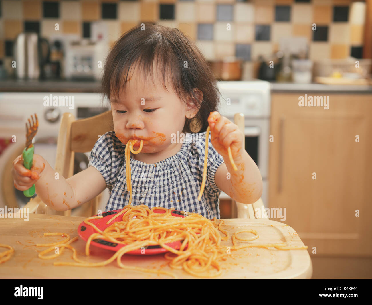 baby girl eating messy spaghetti at home Stock Photo - Alamy