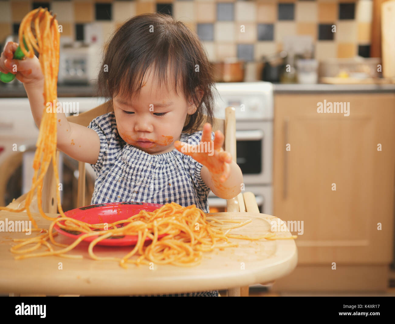 baby girl eating messy spaghetti at home Stock Photo - Alamy