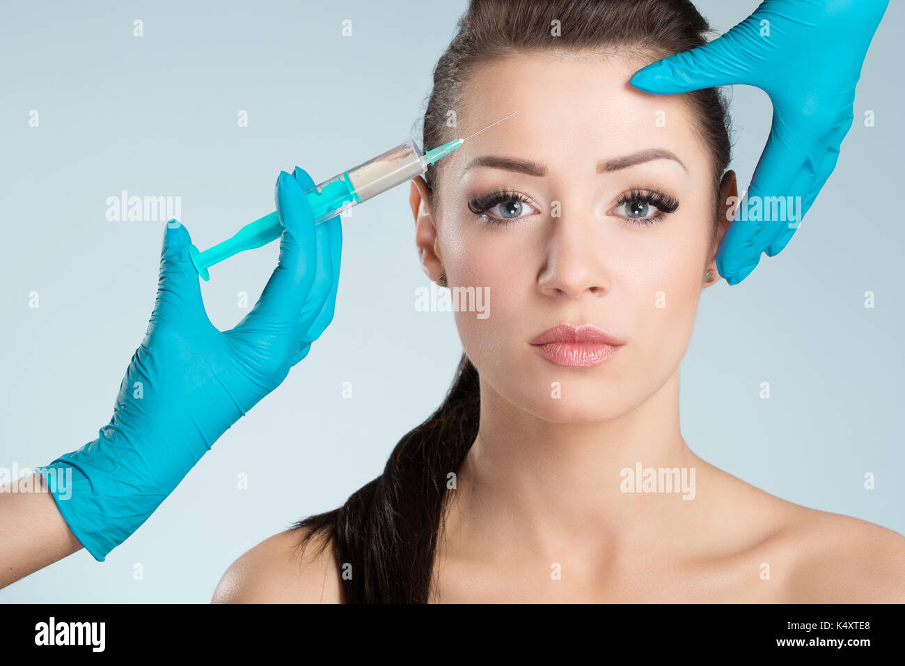 Front portrait of beautiful woman getting face injection Stock Photo ...