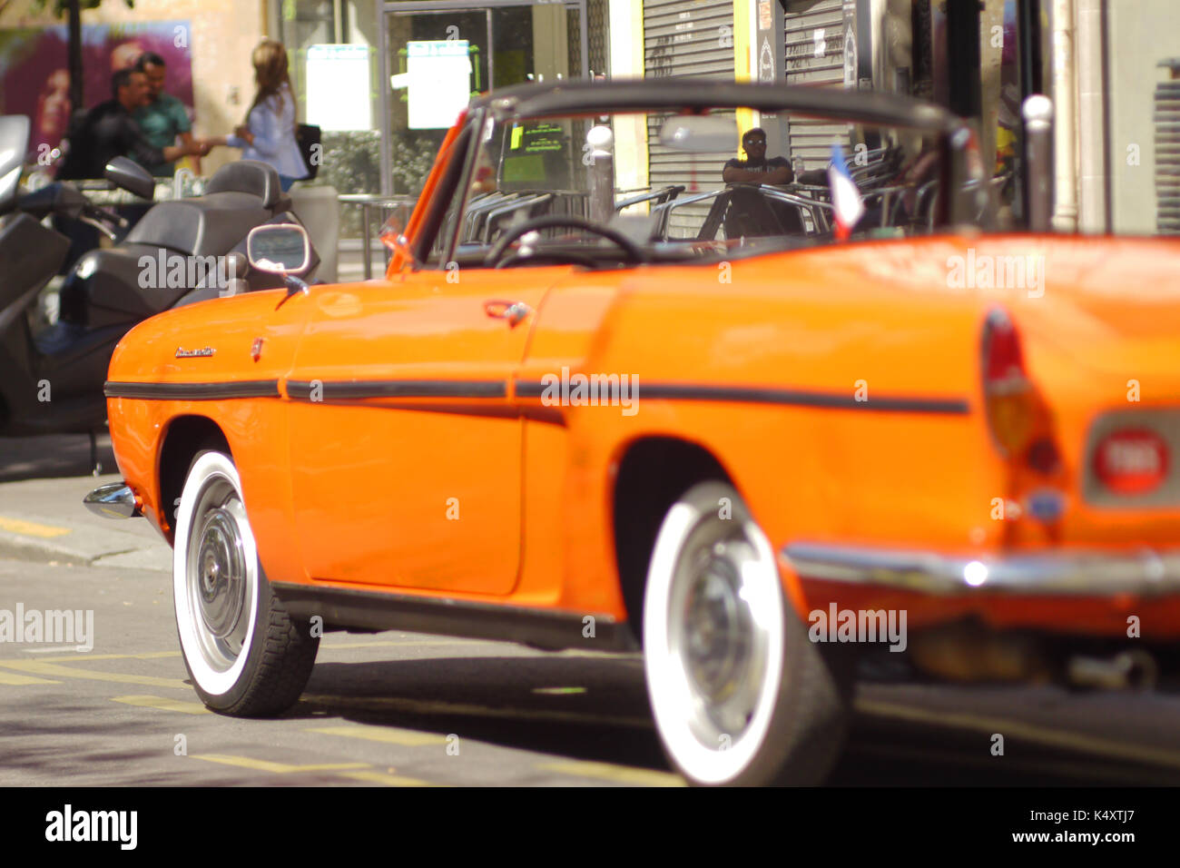 A classic old orange car in Paris France. A beautiful old car parked up ...