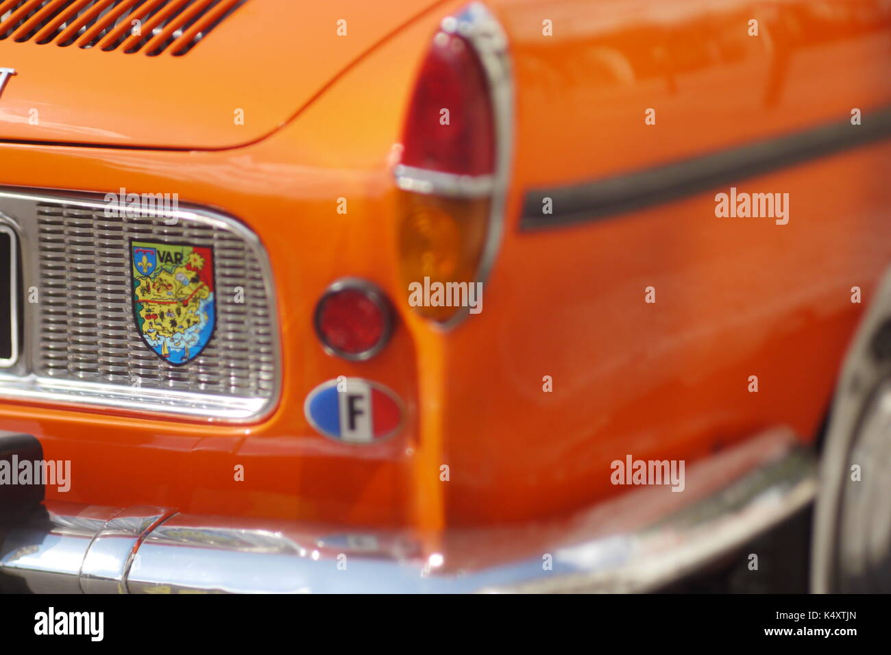 A classic old orange car in Paris France. A beautiful old car parked up ...