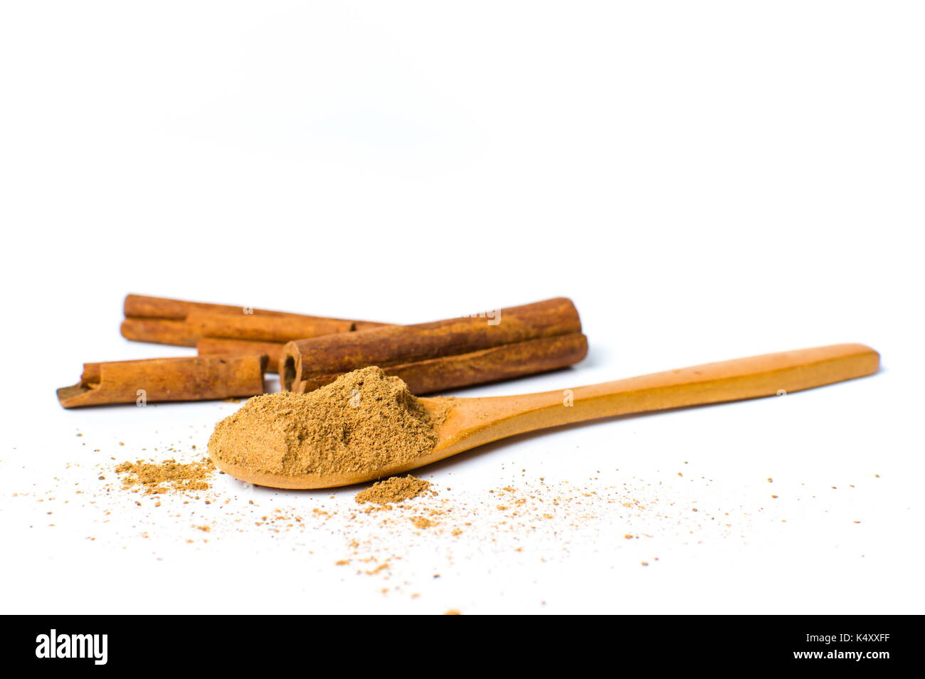 Cinnamon powder in a spoon and sticks isolated Stock Photo - Alamy