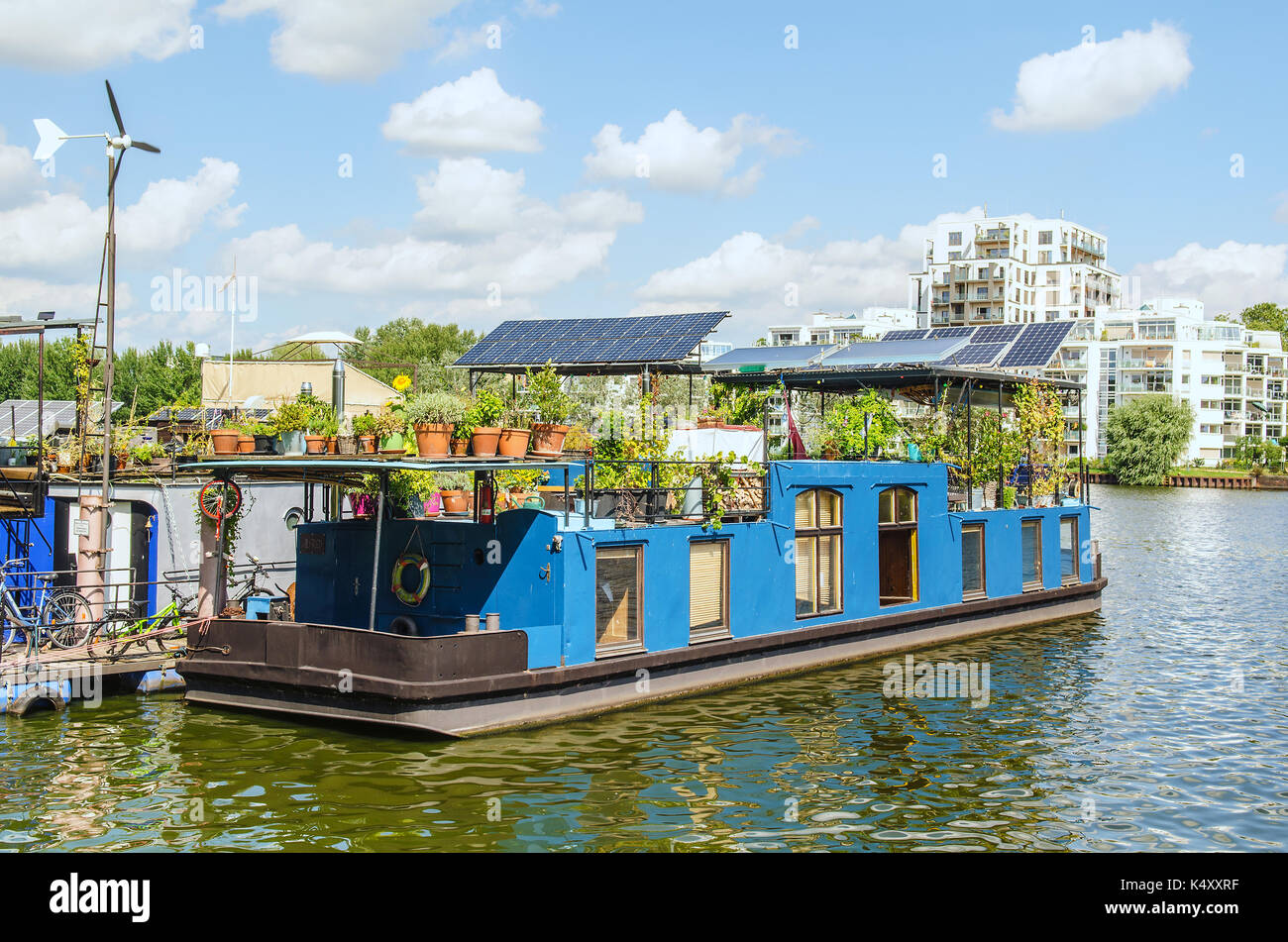 houseboat barge on a river with modern buildings in the background ...