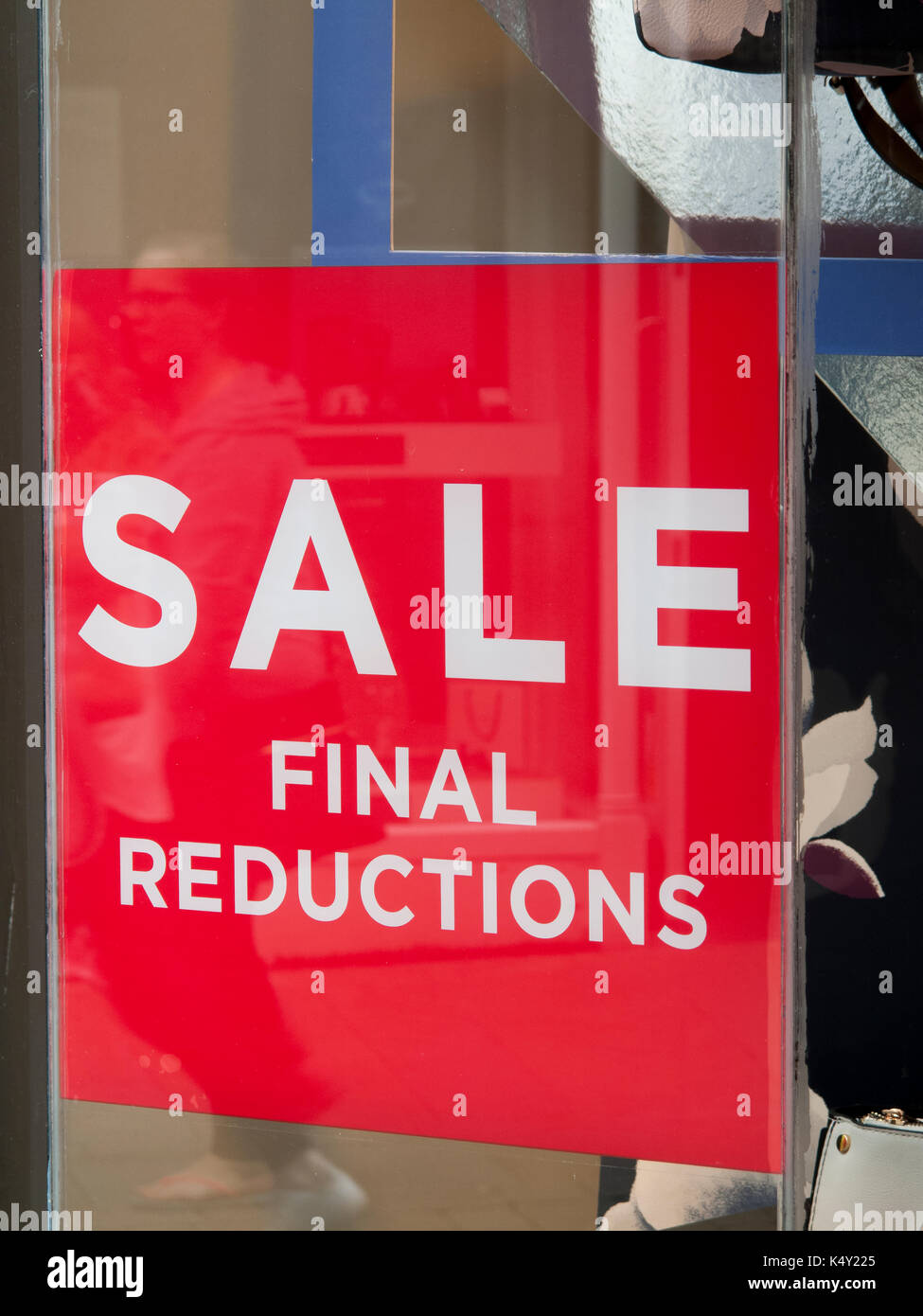Final reductions sale sign in clothing shop window Stock Photo - Alamy