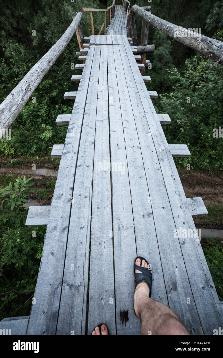 Top view feet in flip flops on narrow wooden bridge over river Stock ...