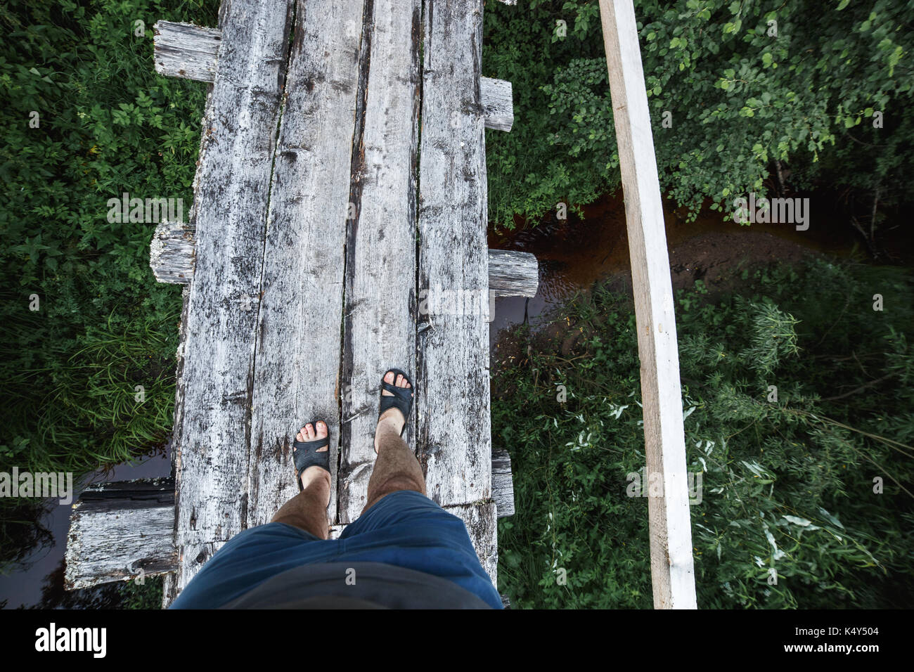 Top view feet in flip flops on narrow wooden bridge over river Stock ...