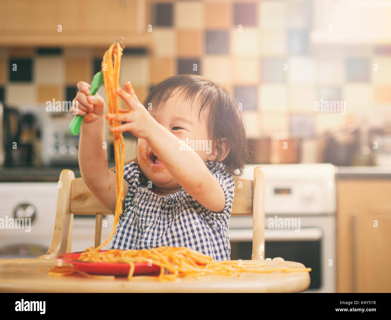 baby girl eating messy spaghetti at home Stock Photo - Alamy