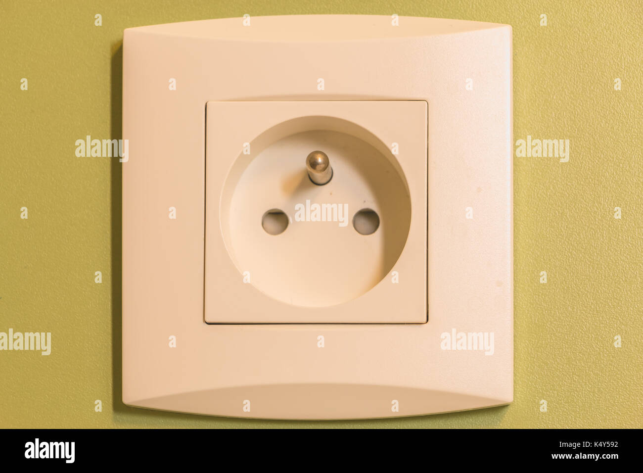 close up residential wall socket on a green wall Stock Photo - Alamy