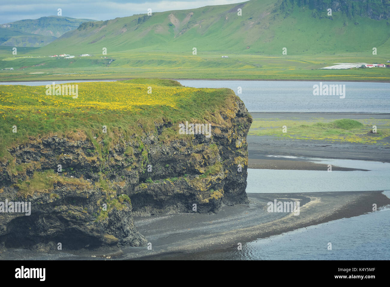 Rocks formation on Dyrholaey cape with black sand beach near Vik town ...