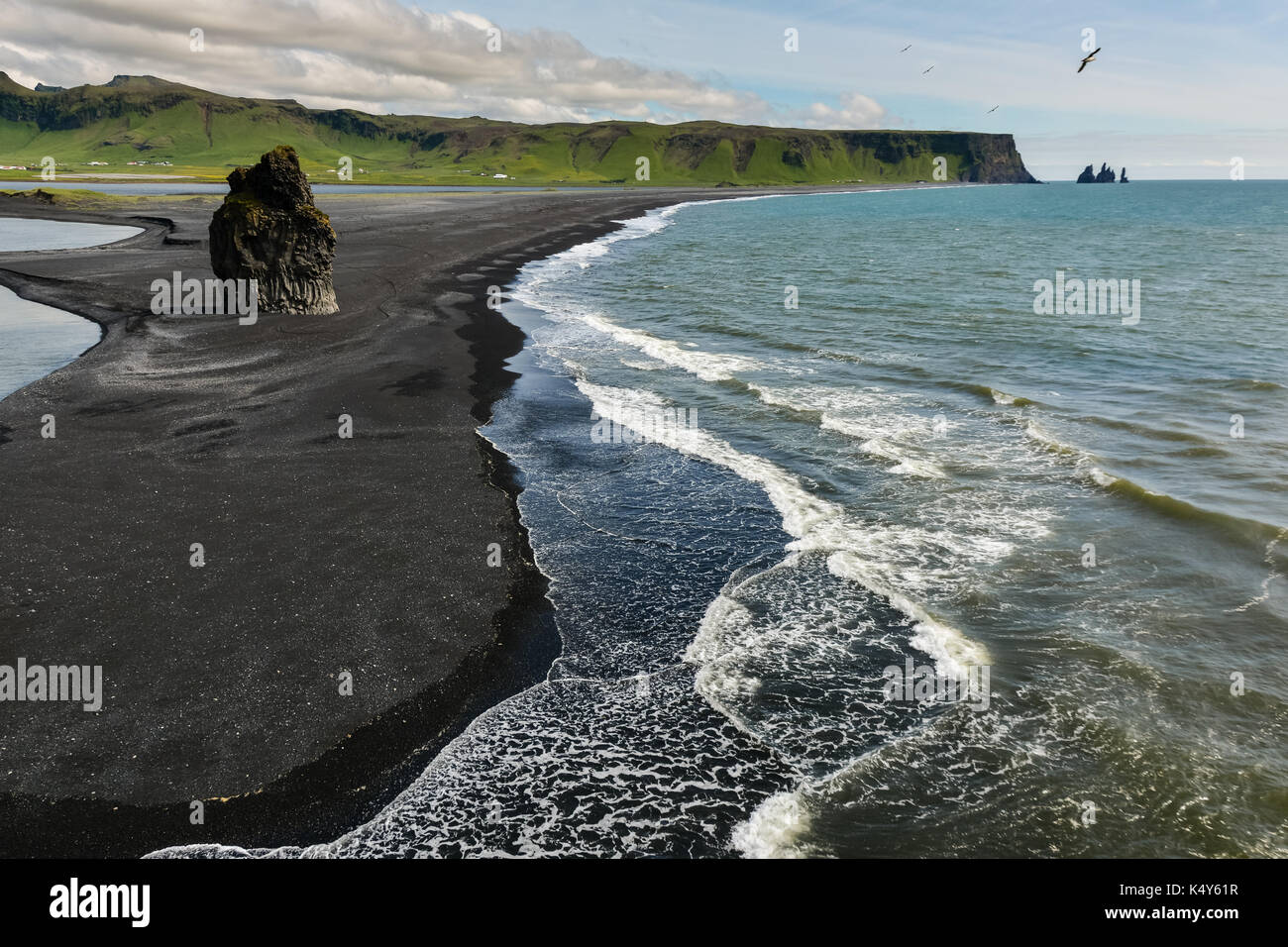 Rocks formation on Dyrholaey cape with black sand beach near Vik town ...