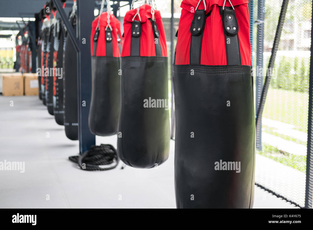 red and black sandbag for hitting and punching in boxing gym. sport ...