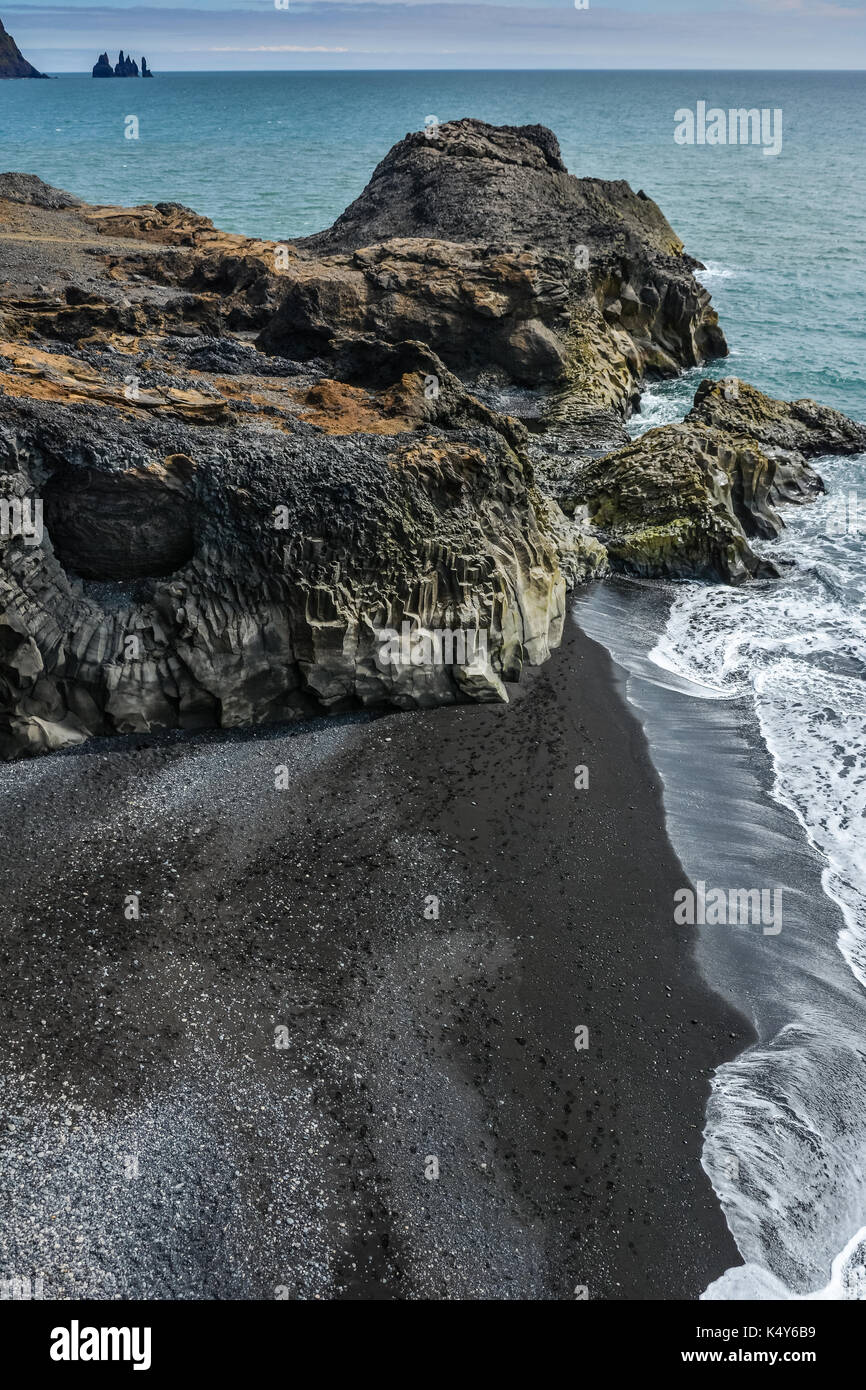 Rocks formation on Dyrholaey cape with black sand beach near Vik town ...