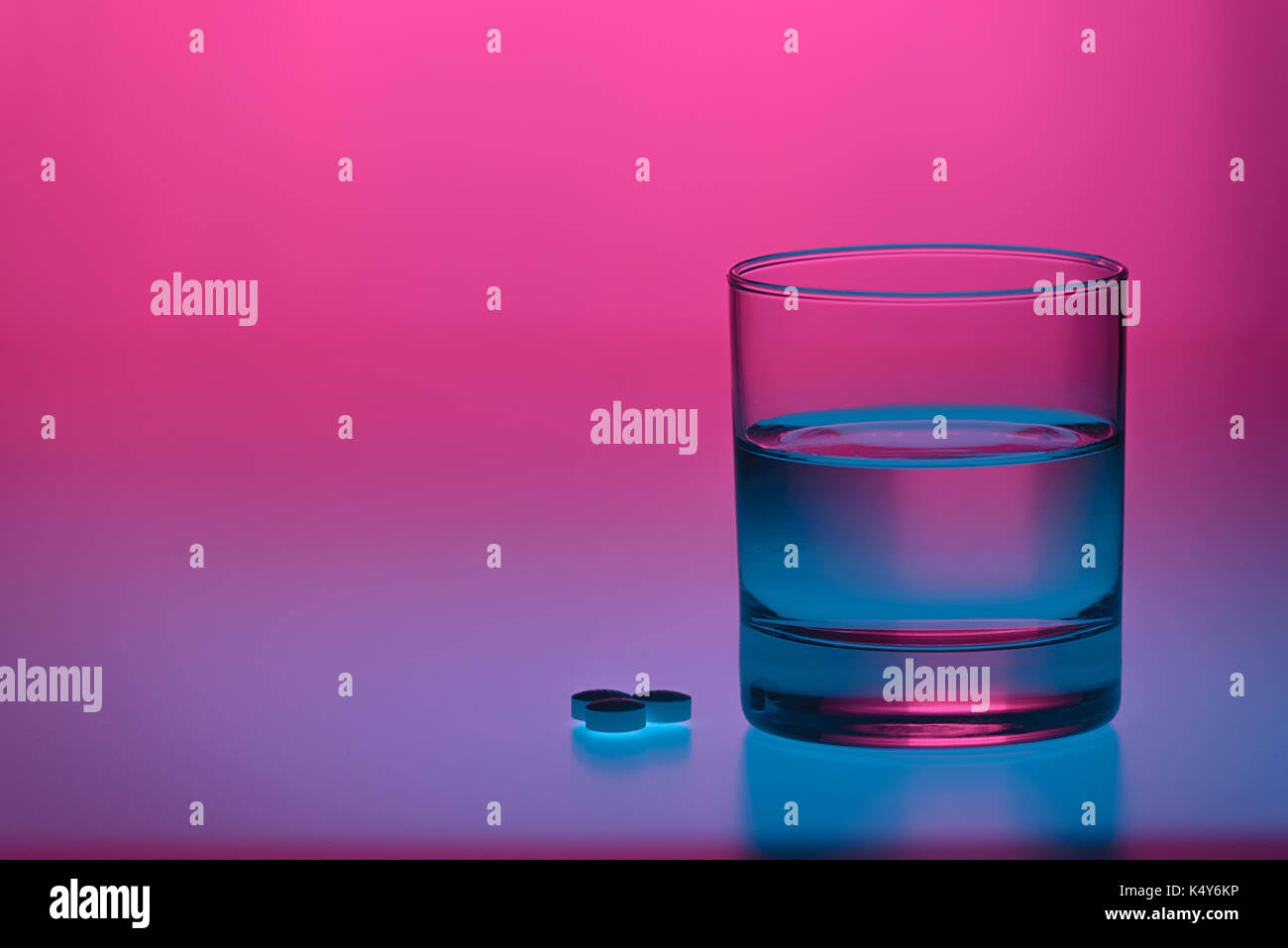 Glass of water, prescription pills on the color background. Colorful ...