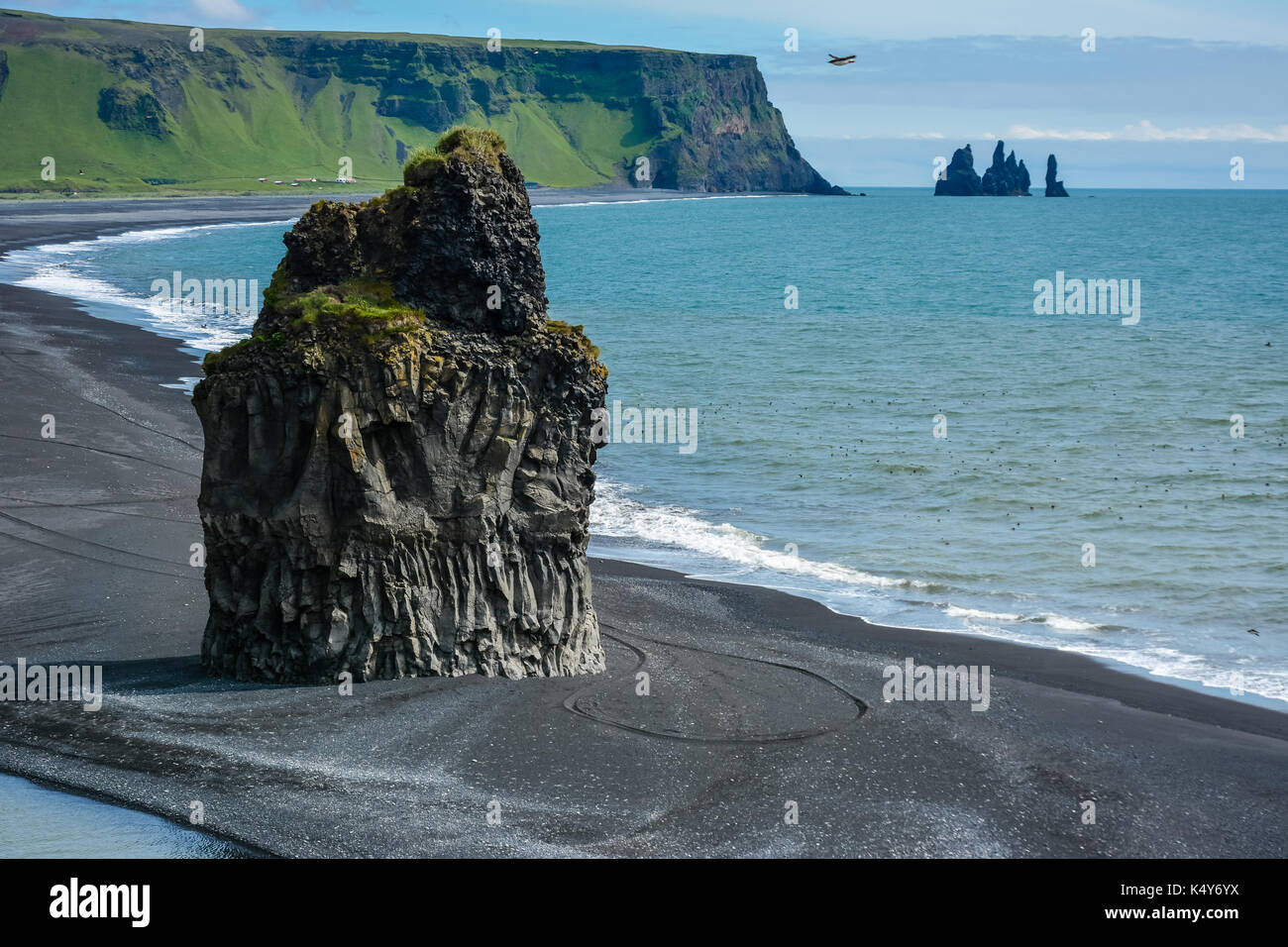 Rocks formation on Dyrholaey cape with black sand beach and puffins ...