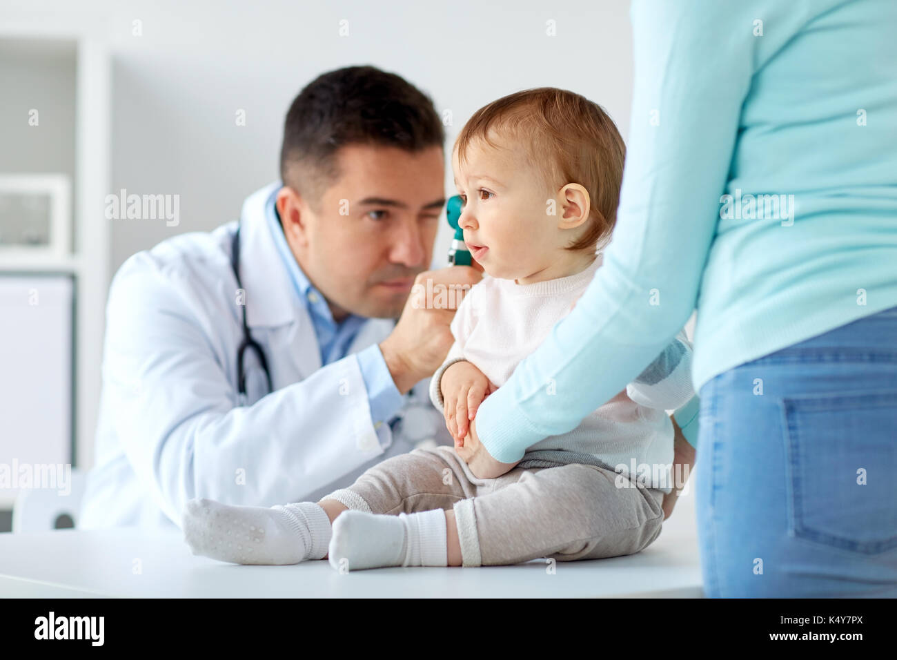 doctor checking baby ear with otoscope at clinic Stock Photo - Alamy