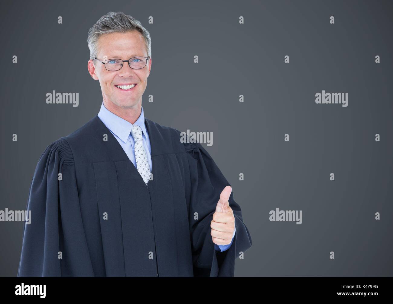 Digital composite of Male judge thumbs up against grey background Stock ...