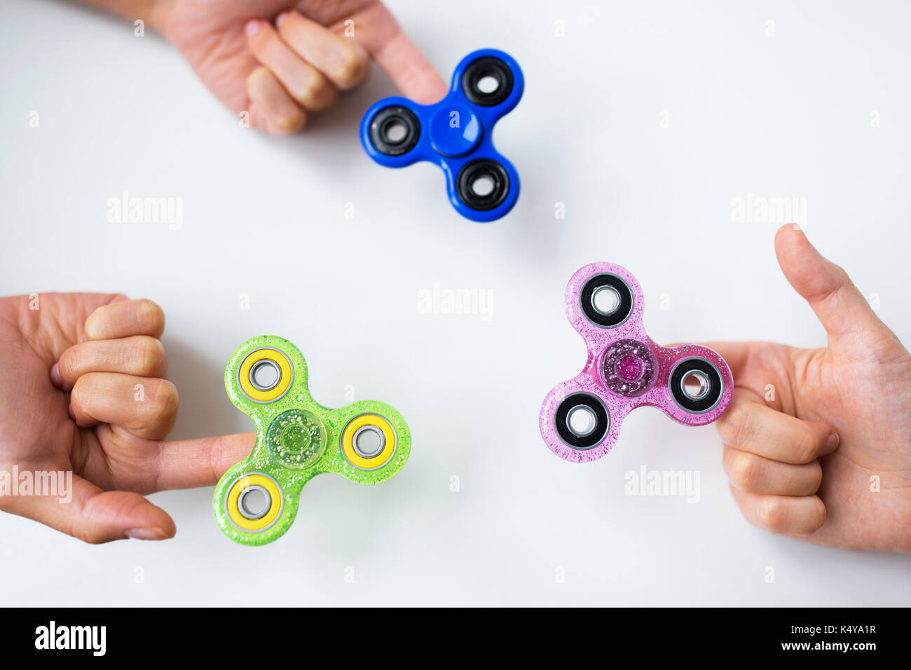close up of hands playing with fidget spinners Stock Photo - Alamy