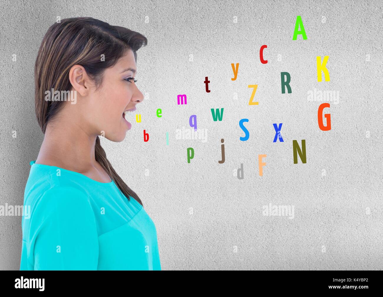 Digital composite of young woman speaking with colour letters coming up ...