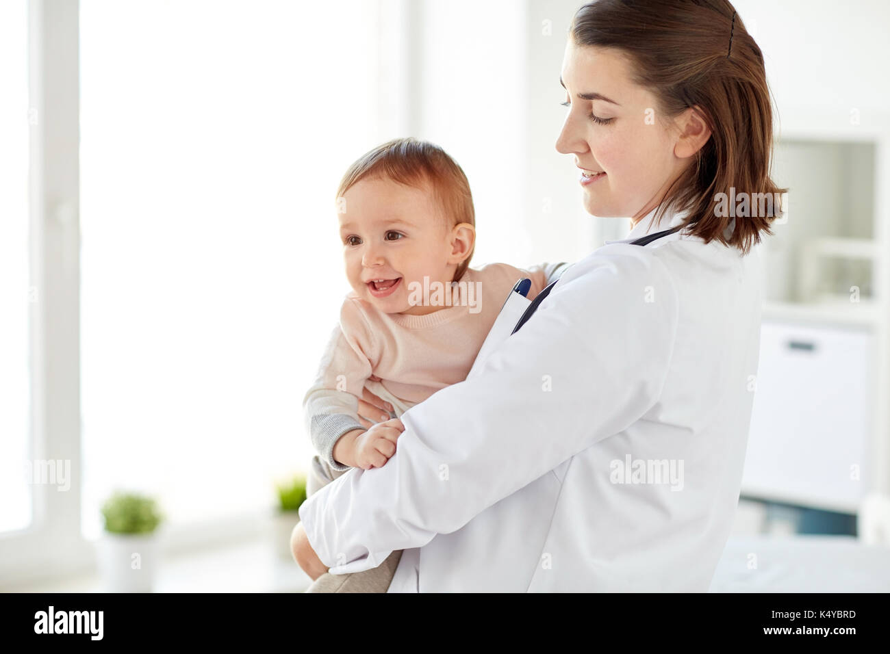 doctor or pediatrician holding baby at clinic Stock Photo - Alamy