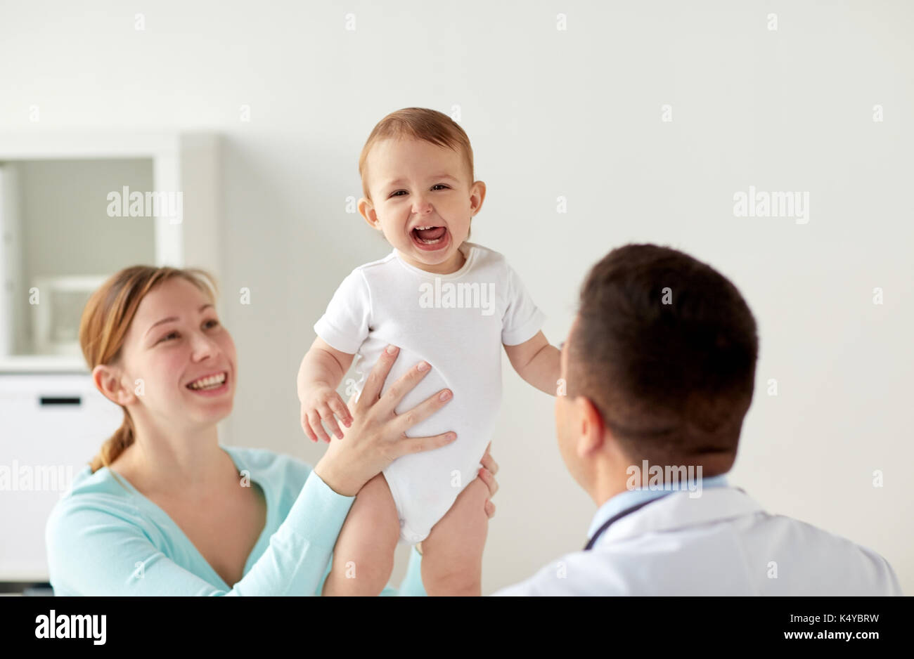 happy woman with baby and doctor at clinic Stock Photo - Alamy