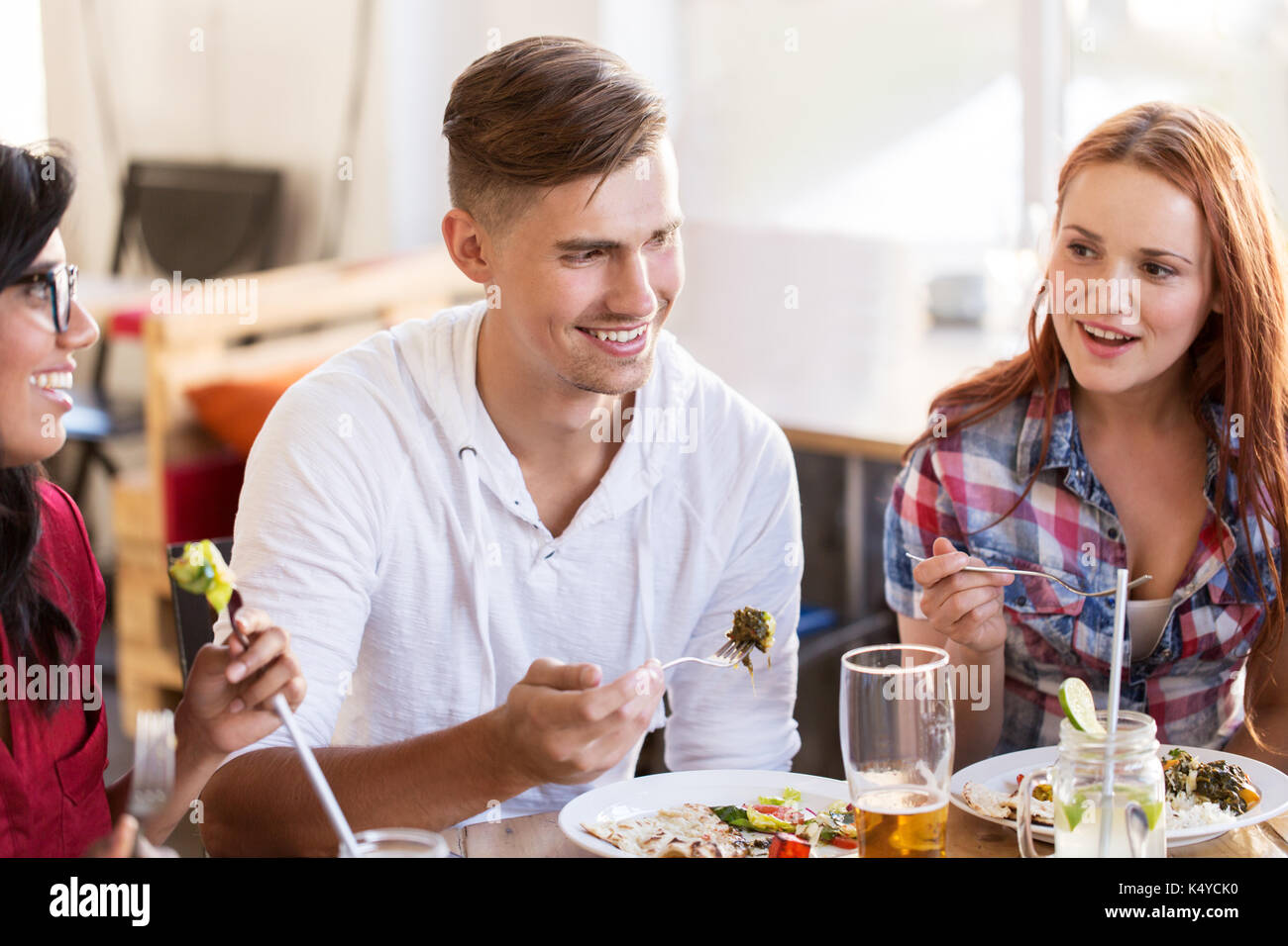 happy friends eating and talking at restaurant Stock Photo - Alamy