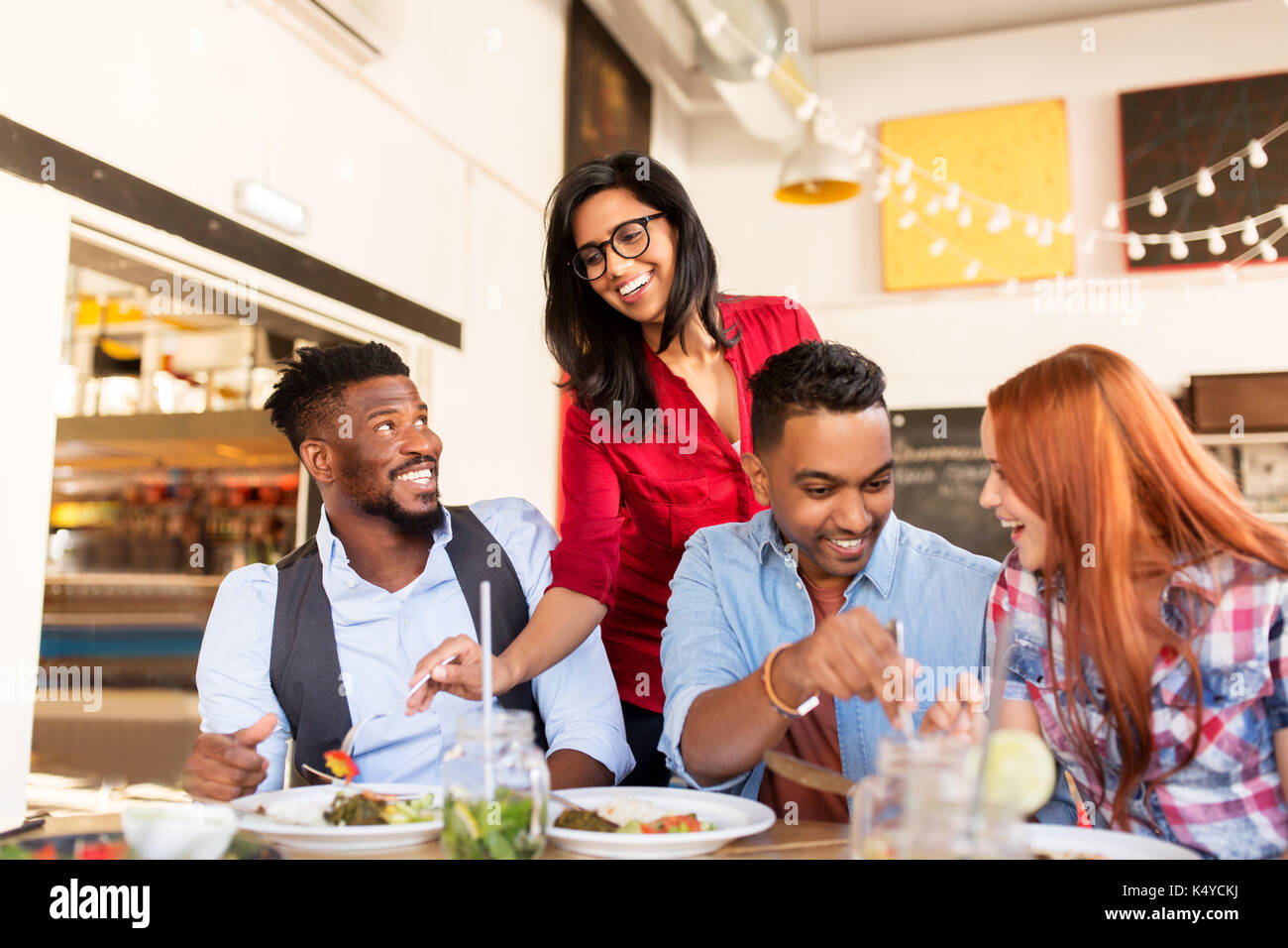 happy friends eating at restaurant Stock Photo - Alamy