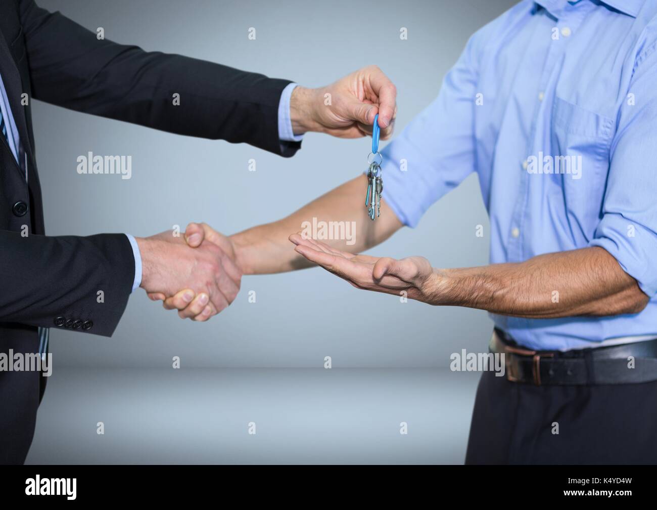 Digital composite of Men holding keys handshake in front of vignette ...