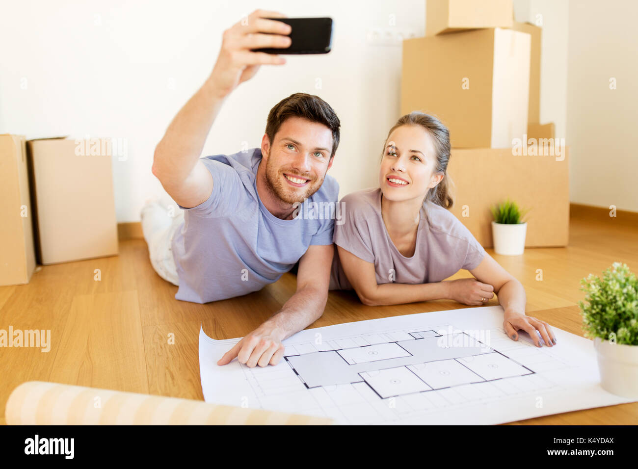 couple with boxes and blueprint moving to new home Stock Photo - Alamy