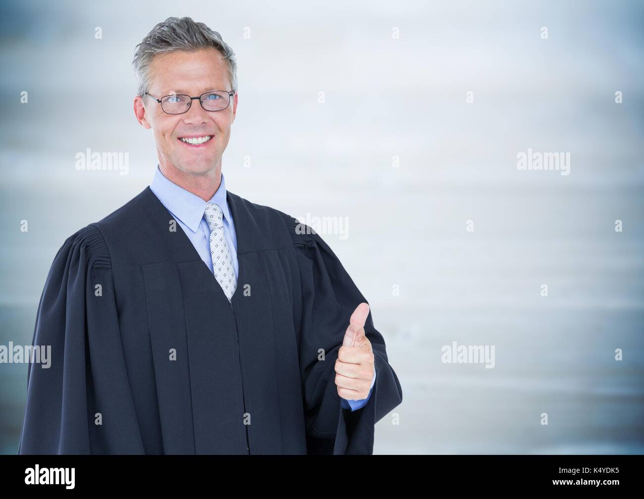 Digital composite of Male judge thumbs up against blurry blue wood ...