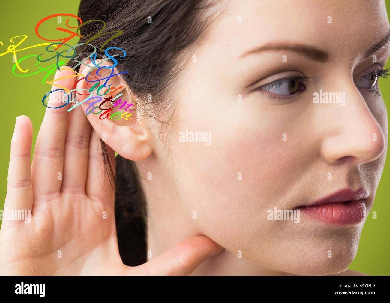 Digital composite of woman ear with colour letters coming up from that ...