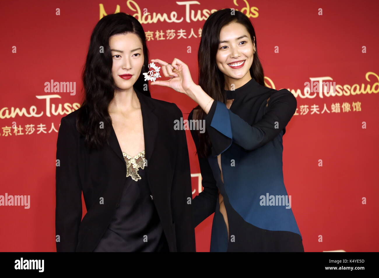 Chinese model Liu Wen (right) poses with a wax figure of her at the ...