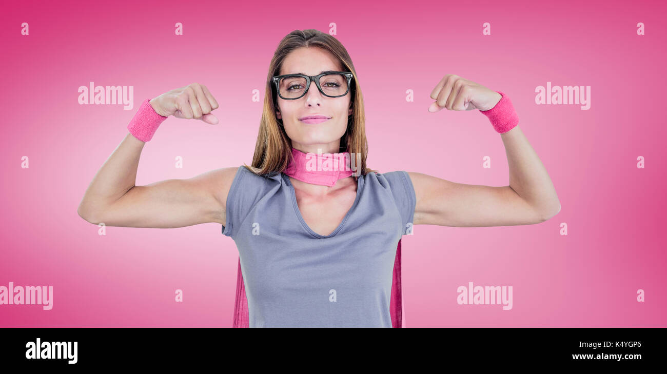 Portrait of smiling woman in superhero costume while flexing muscles ...
