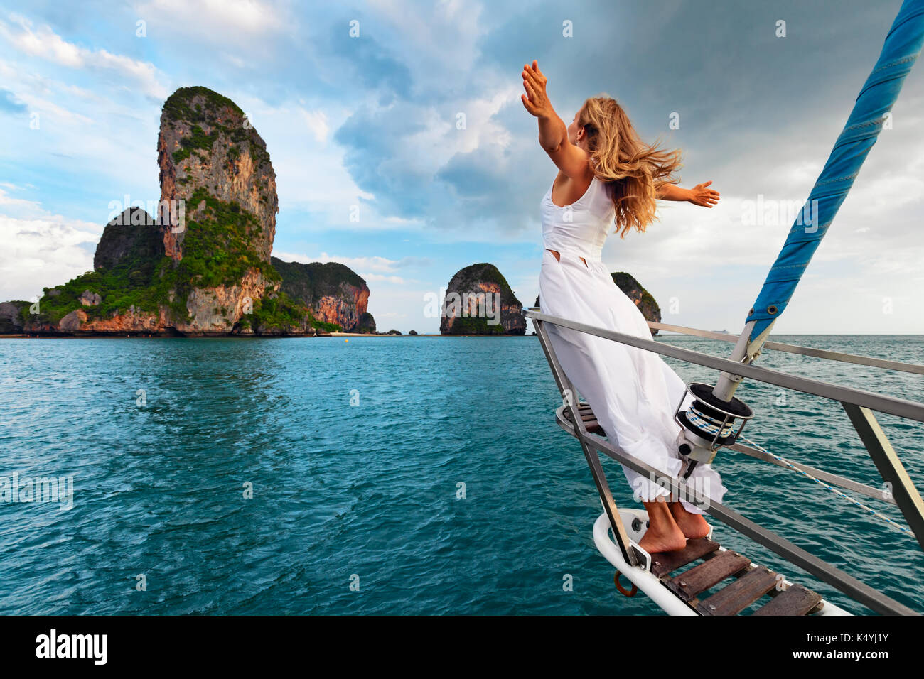Joyful young woman portrait. Happy girl stand on deck of sailing yacht ...