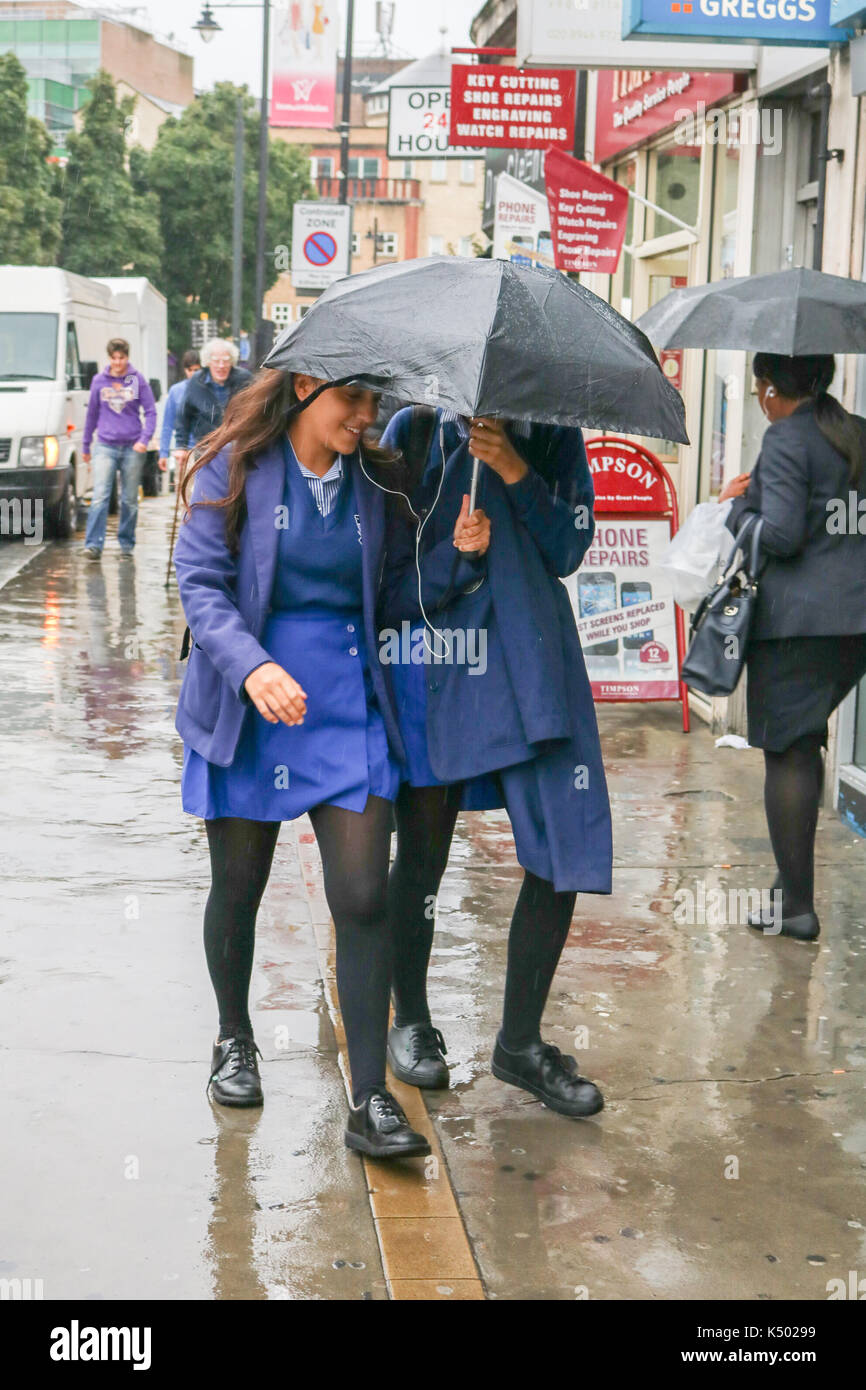 London, UK. 8th Sep, 2017. Two schoolgirls shelter from the rains and ...