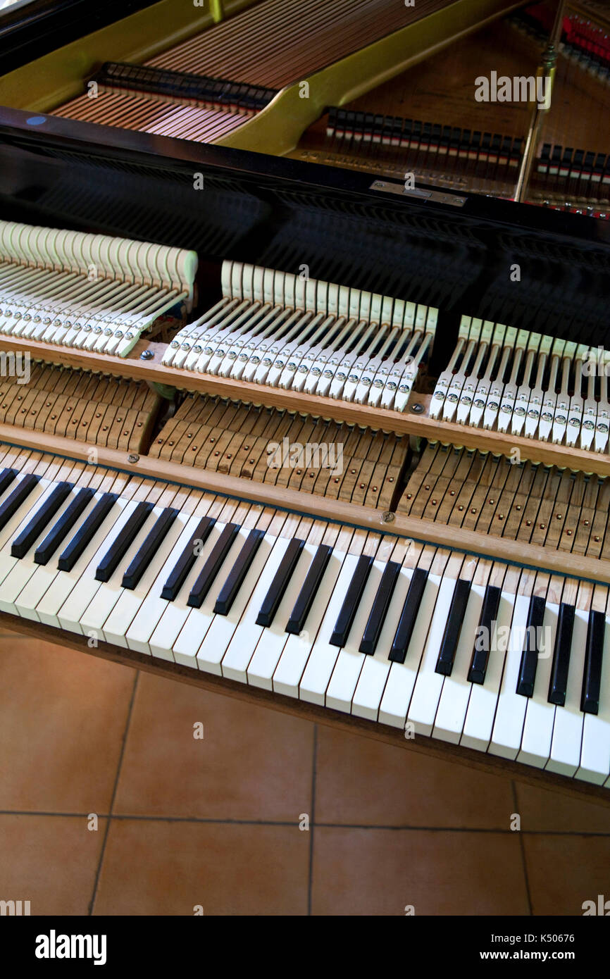 Keyboard and interior of a gran piano on a tiled floor Stock Photo - Alamy