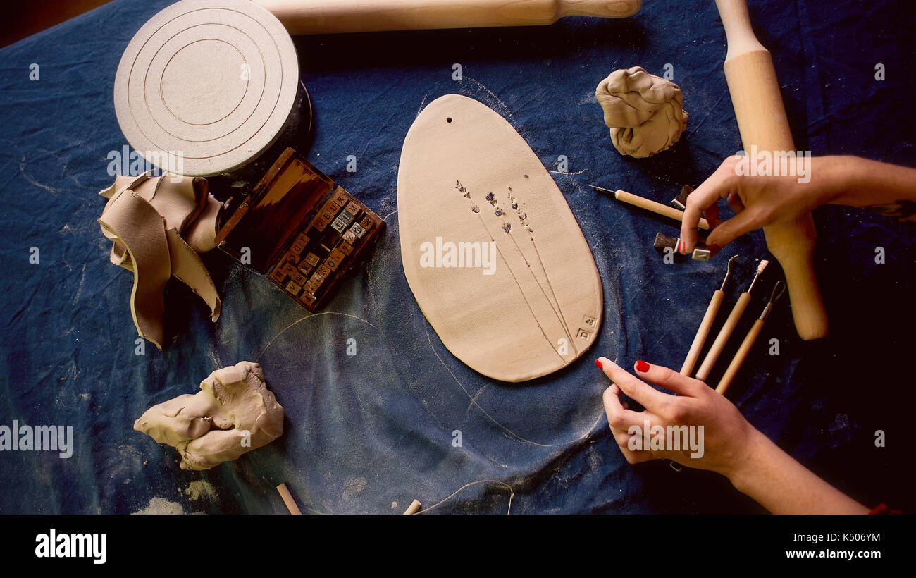 master shapes pottery on a blue canvas.Creative process. Gives shape to ...