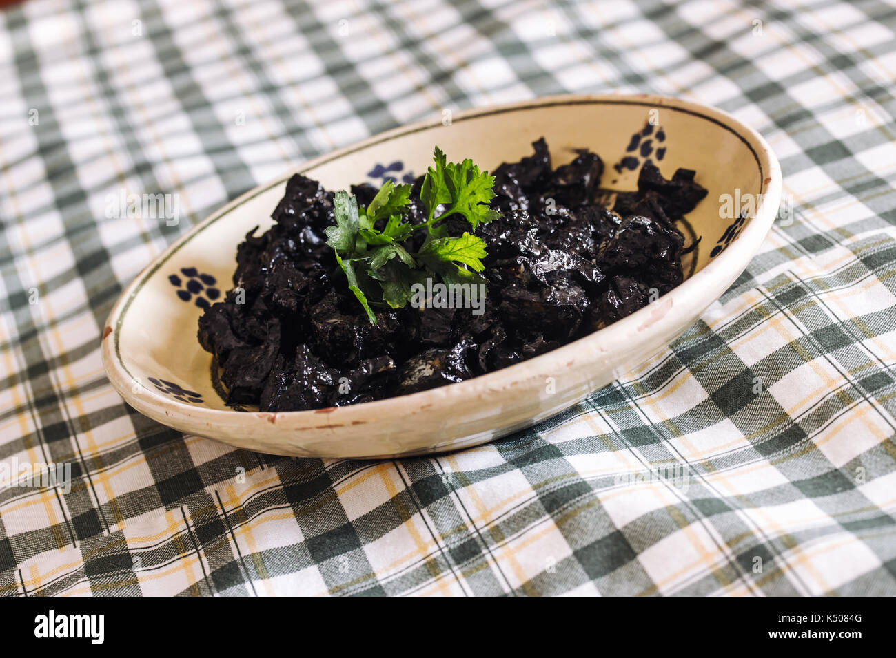 Traditional cuttlefish chops in its own black ink Stock Photo - Alamy