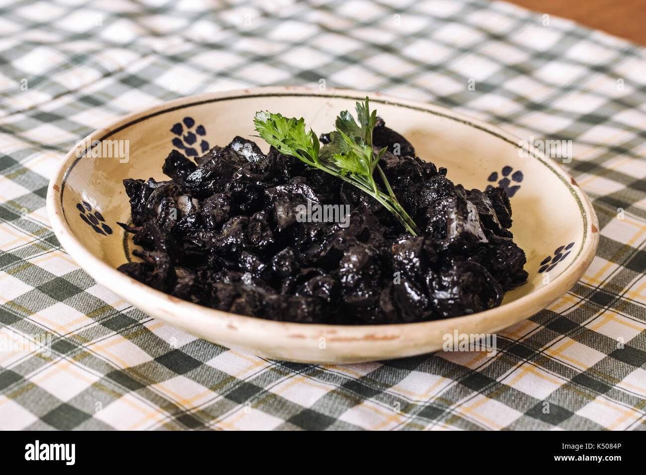 Traditional cuttlefish chops in its own black ink Stock Photo - Alamy