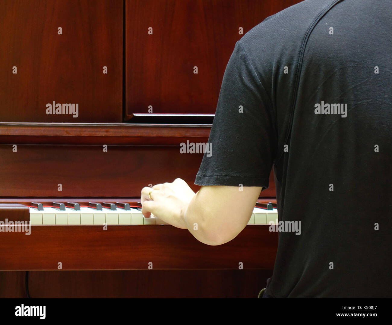 Back view of music performer playing piano at luxury hotel Stock Photo ...