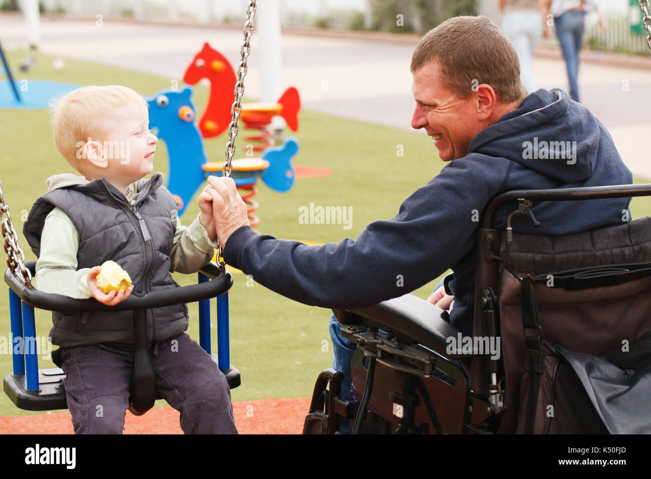 Disabled father play with his little son on the playground Stock Photo ...