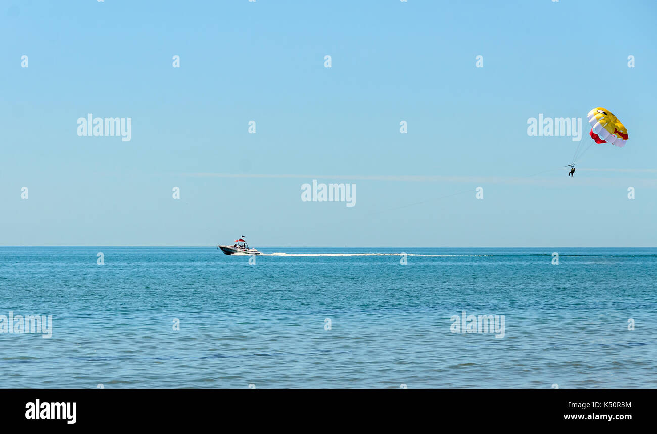 Colored parasail wing pulled by a boat in the sea water, Parasailing ...
