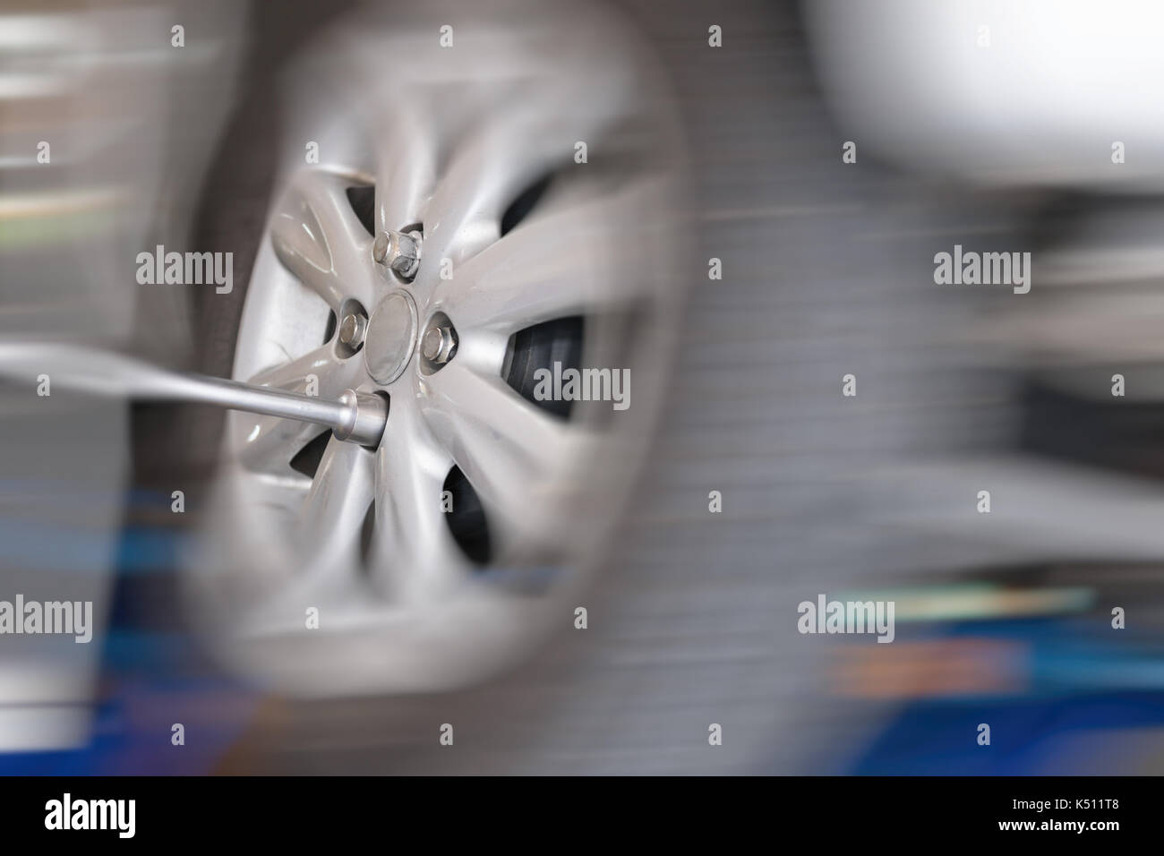Mechanic changing car wheel in auto repair shop. serviceman wrenching ...