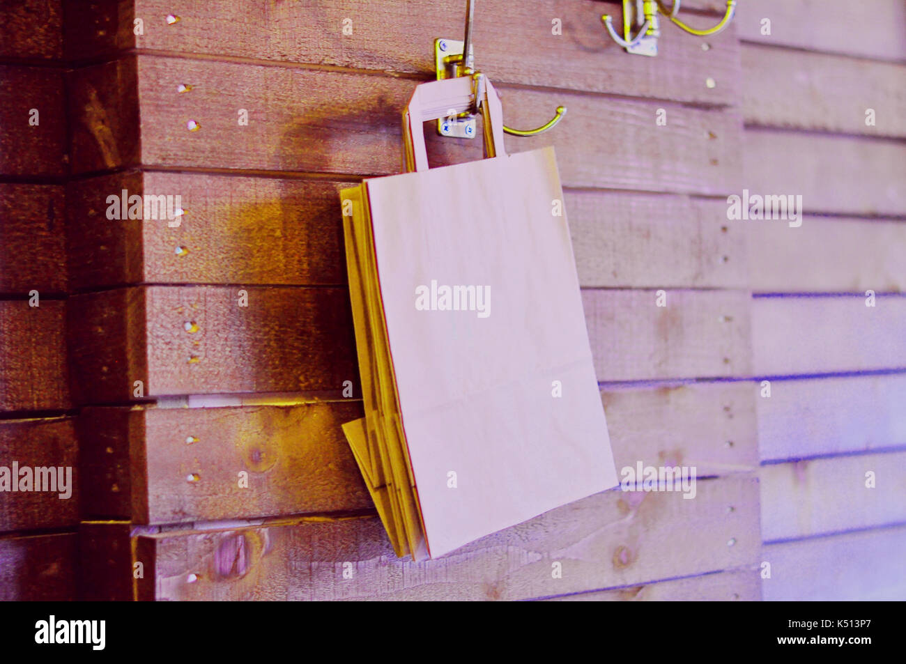 Paper bag hanging on hook on wooden wall Stock Photo - Alamy