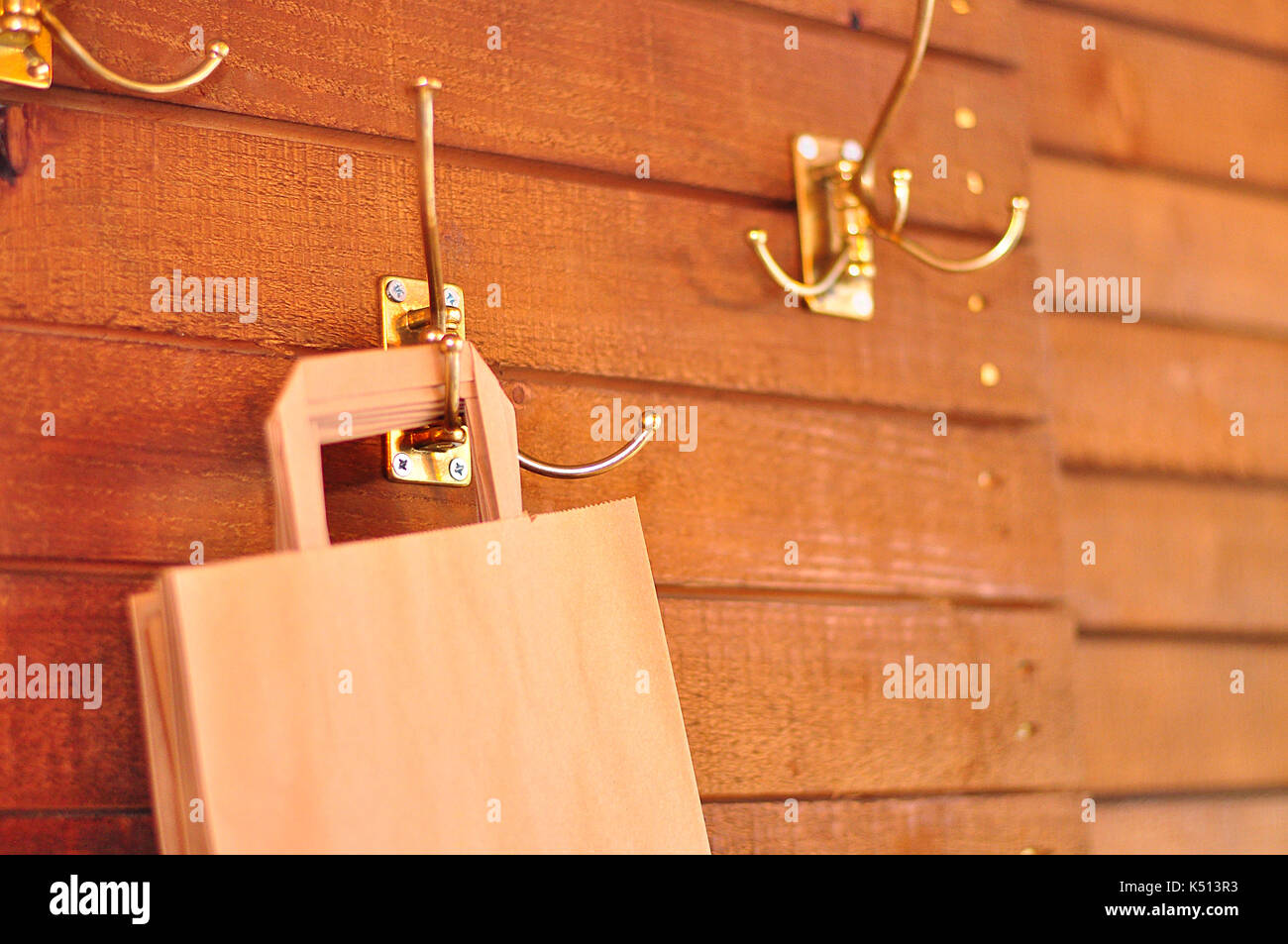 Paper bag hanging on hook on wooden wall Stock Photo - Alamy