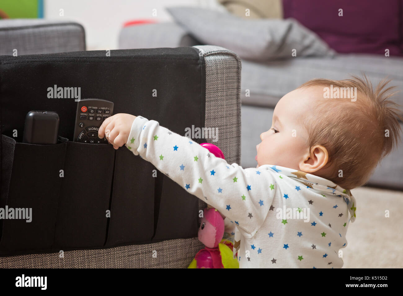 Nine months old baby girl grabbing the TV remote control Stock Photo ...